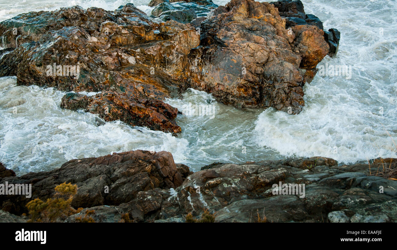 Ocean surf swirls around rugged rock formations Stock Photo - Alamy