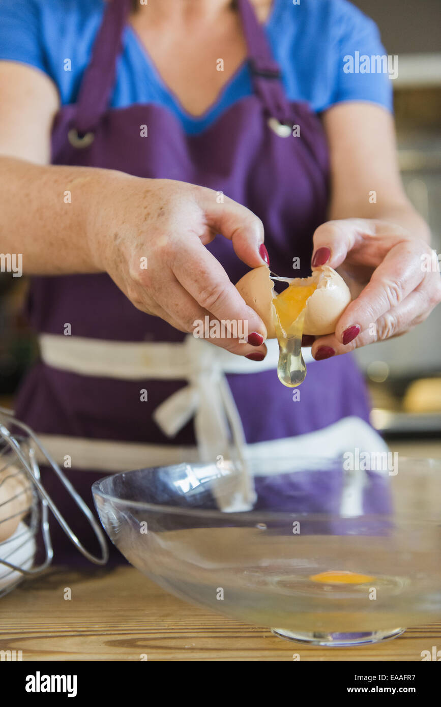 A woman at a kitchen table baking fairy cakes Stock Photo - Alamy