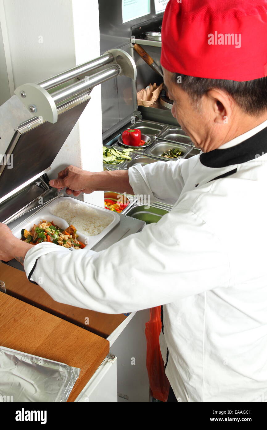 A Asia cook shrink-wrapping a thermo cup Stock Photo - Alamy