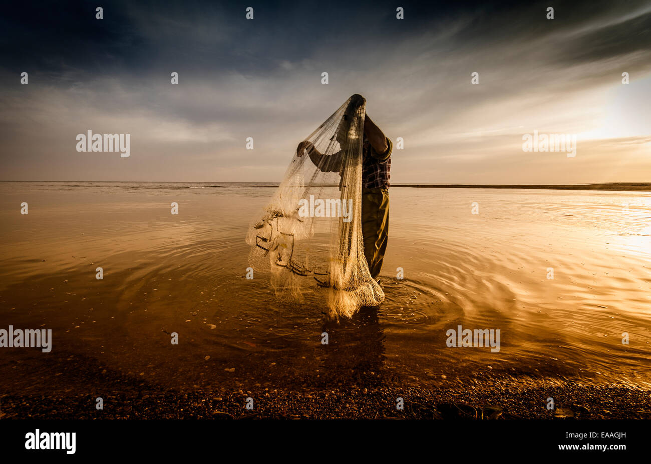 Throwing fishing net during sunset, Greece Stock Photo - Alamy
