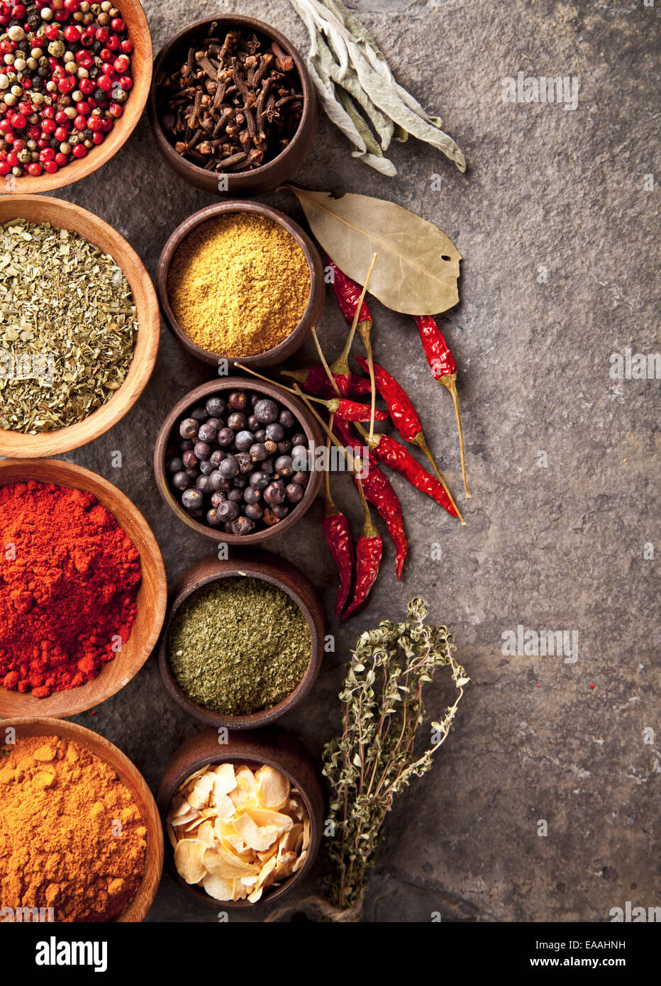 Various spices in wooden bowls on stone surface Stock Photo - Alamy