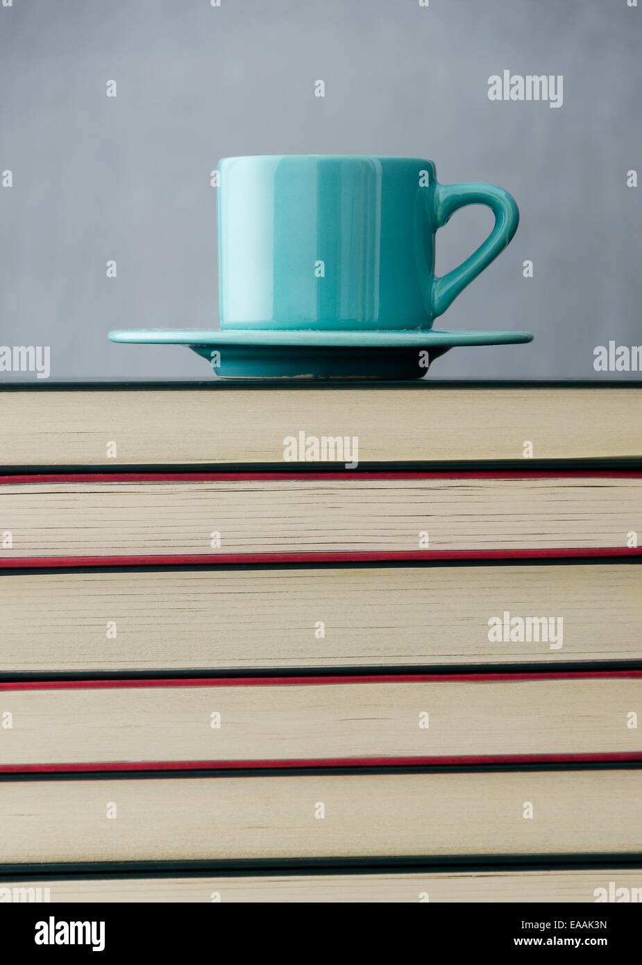 Blue coffee cup on stack of books Stock Photo - Alamy