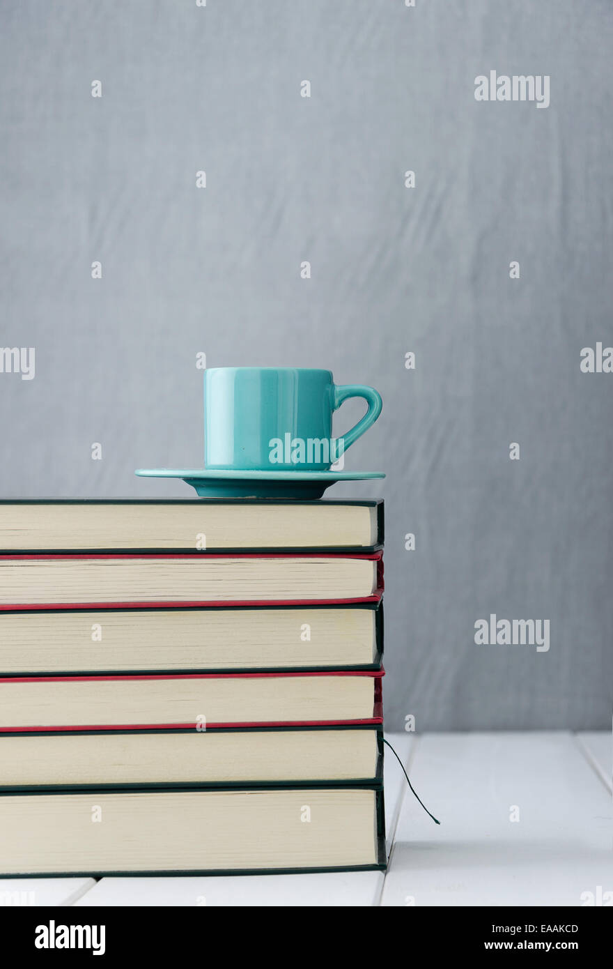 Blue coffee cup on stack of books Stock Photo - Alamy