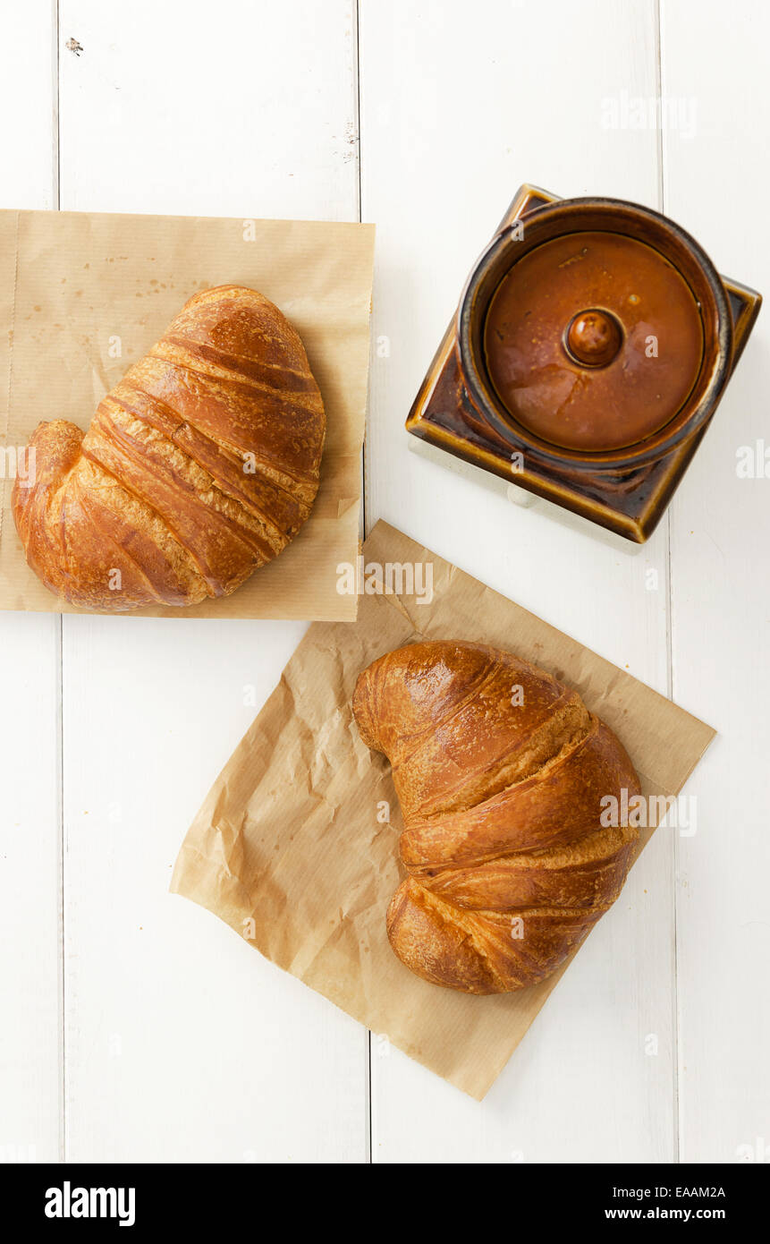 Two croissant over wooden table. Overhead view Stock Photo - Alamy