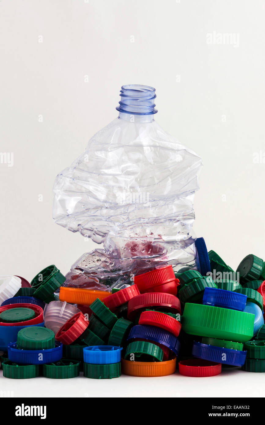 lots of plastic caps with a plastic crushed bottle isolated on white ...