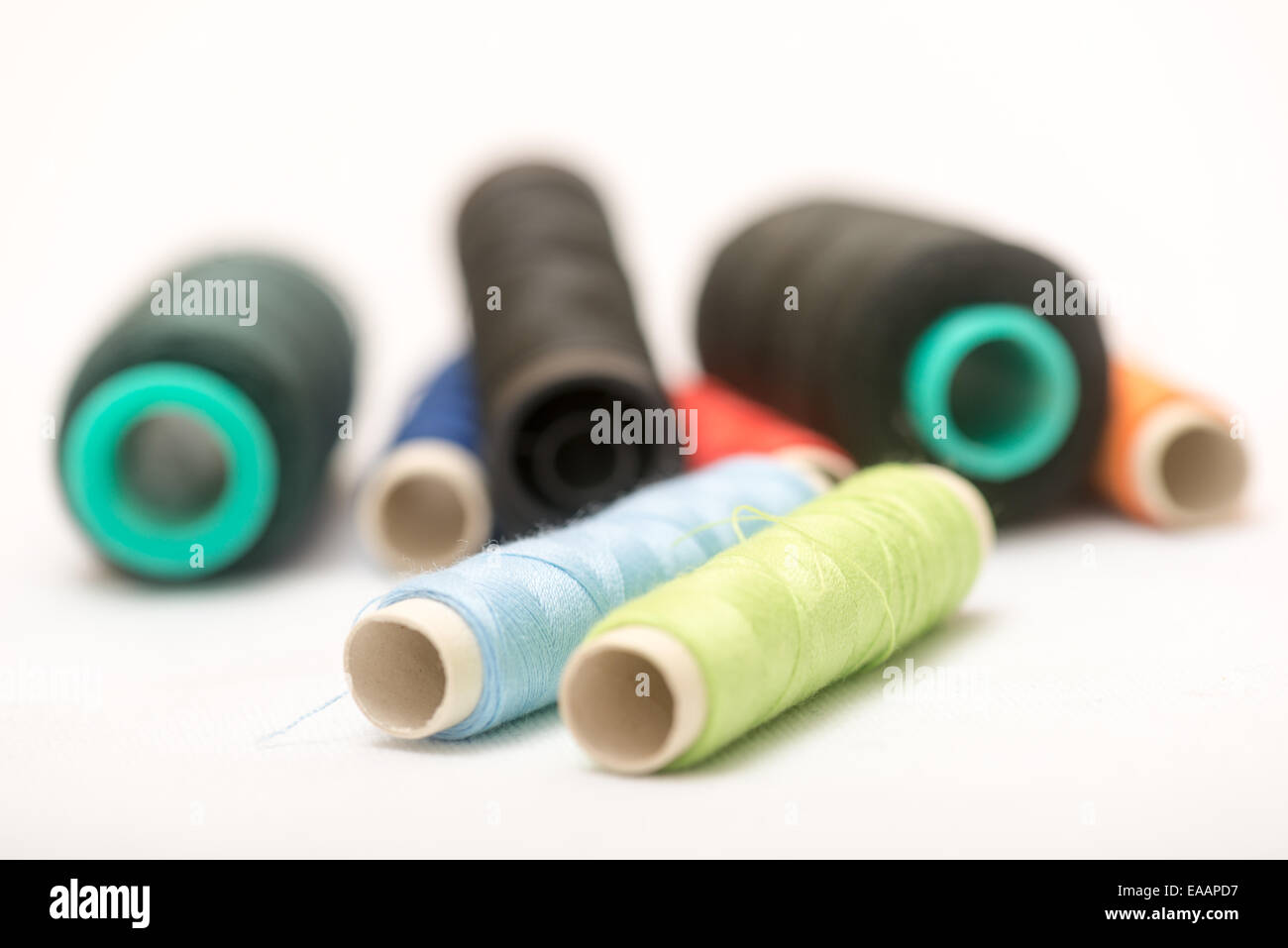 set of colorful spools of thread on a white background Stock Photo - Alamy