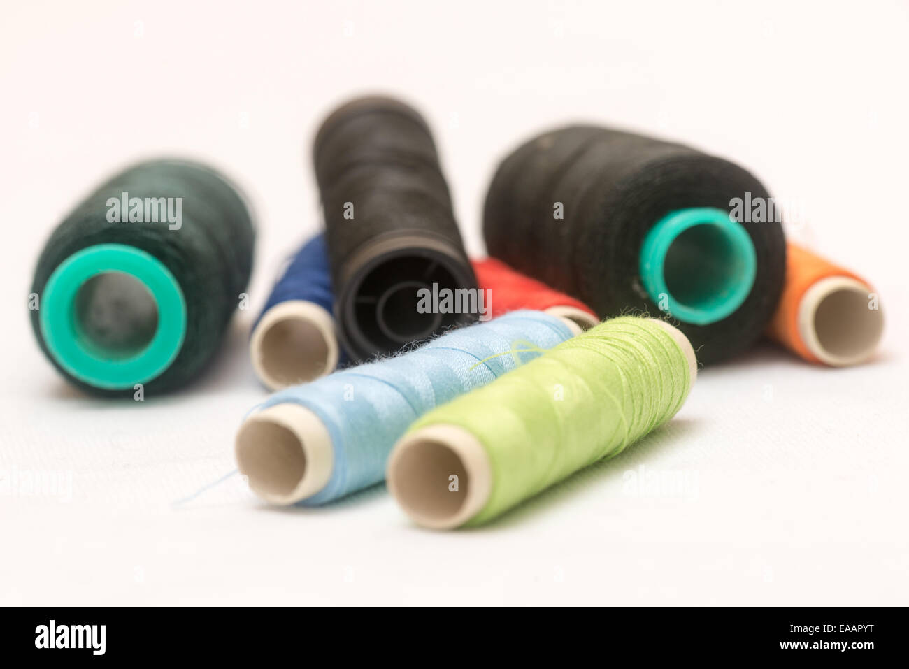 set of colorful spools of thread on a white background Stock Photo - Alamy