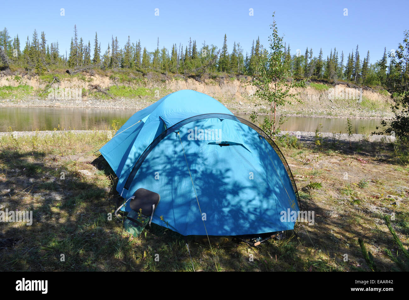 Camping tent on the shore of a mountain river. Polar Ural, Komi ...