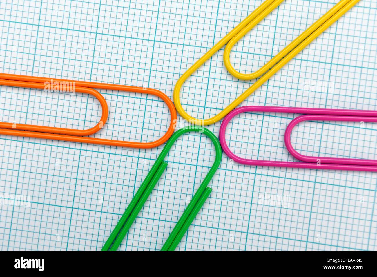 Giant paper clips arranged on a graph paper background Stock Photo - Alamy