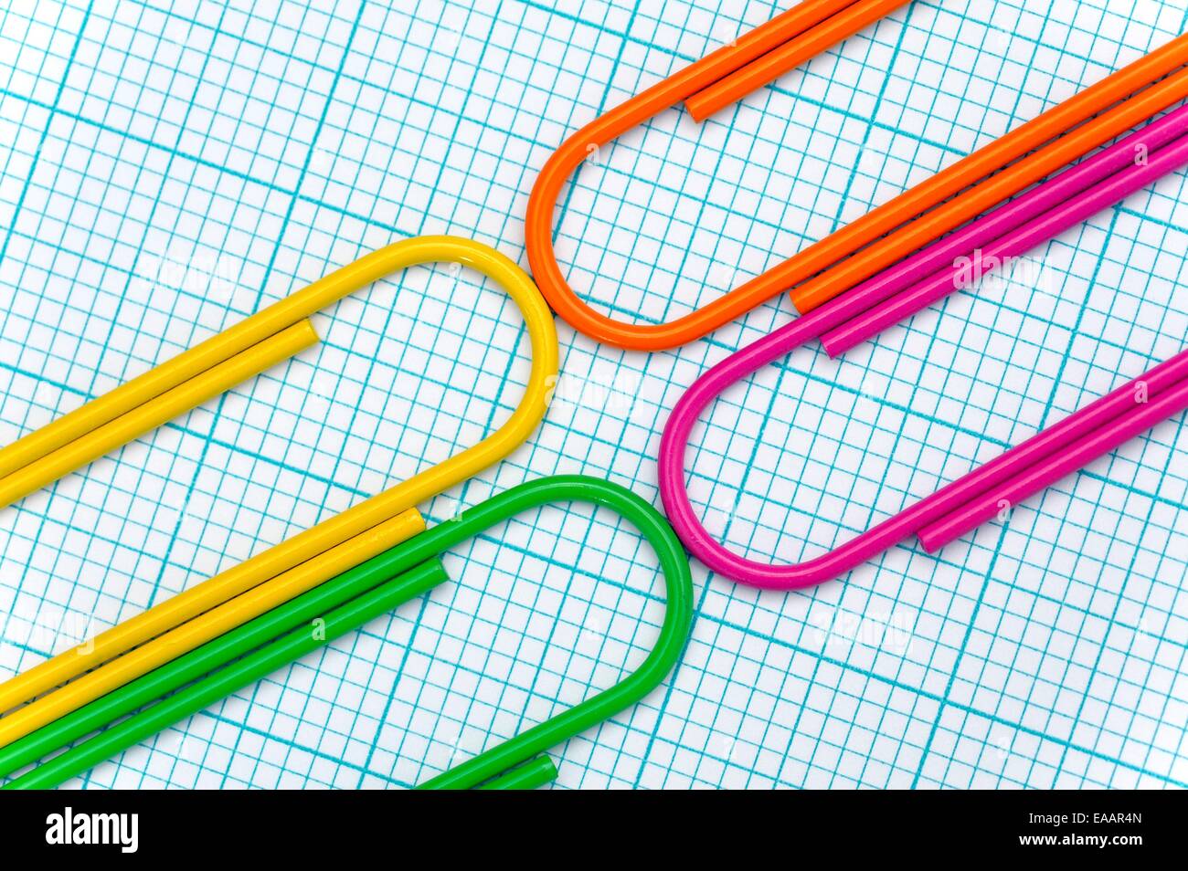 Giant paper clips arranged on a graph paper background Stock Photo - Alamy