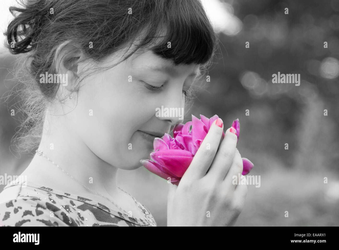 A young, smiling girl with pink flower Stock Photo - Alamy