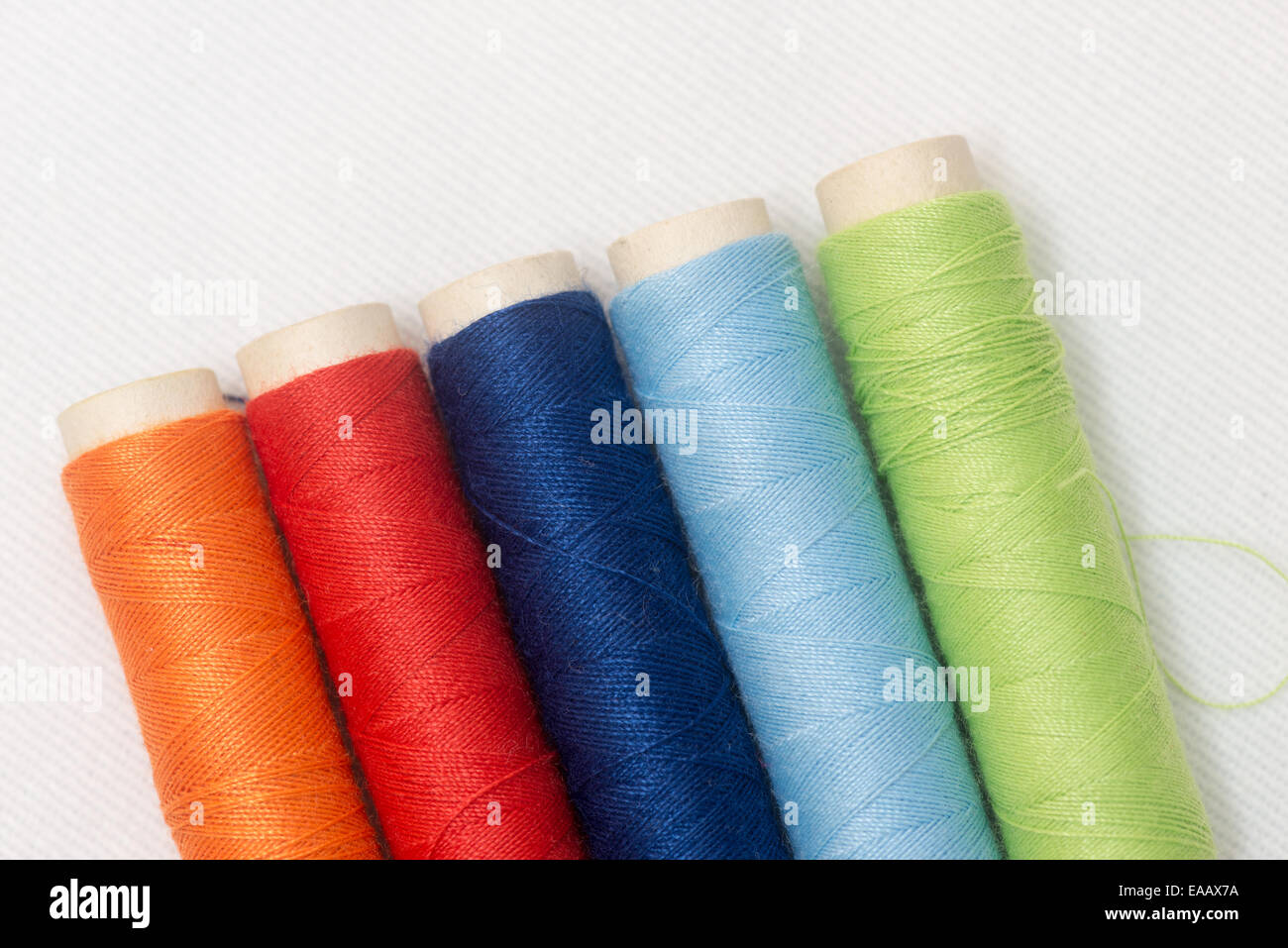 set of colorful spools of thread on a white background Stock Photo - Alamy
