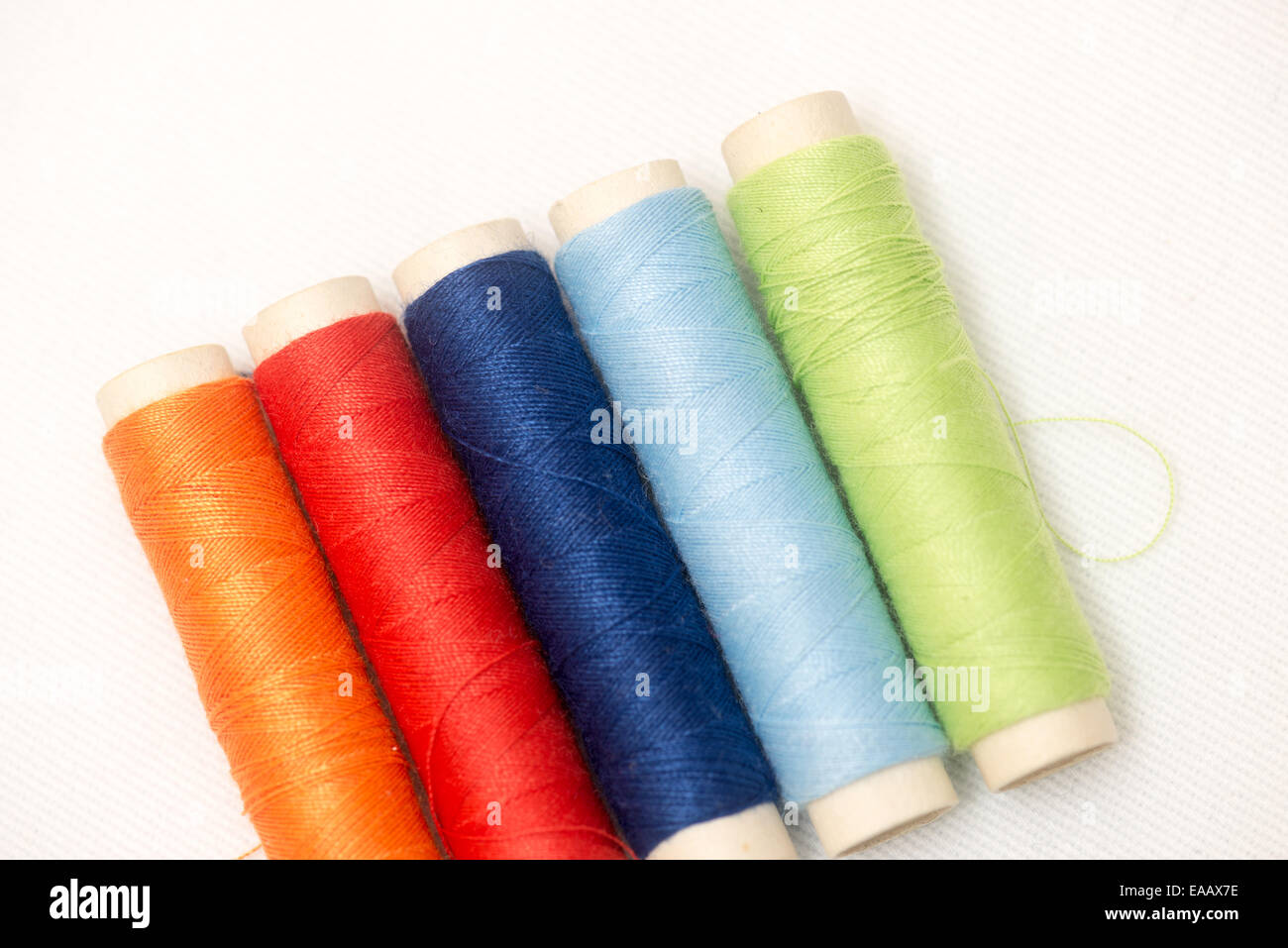 set of colorful spools of thread on a white background Stock Photo - Alamy