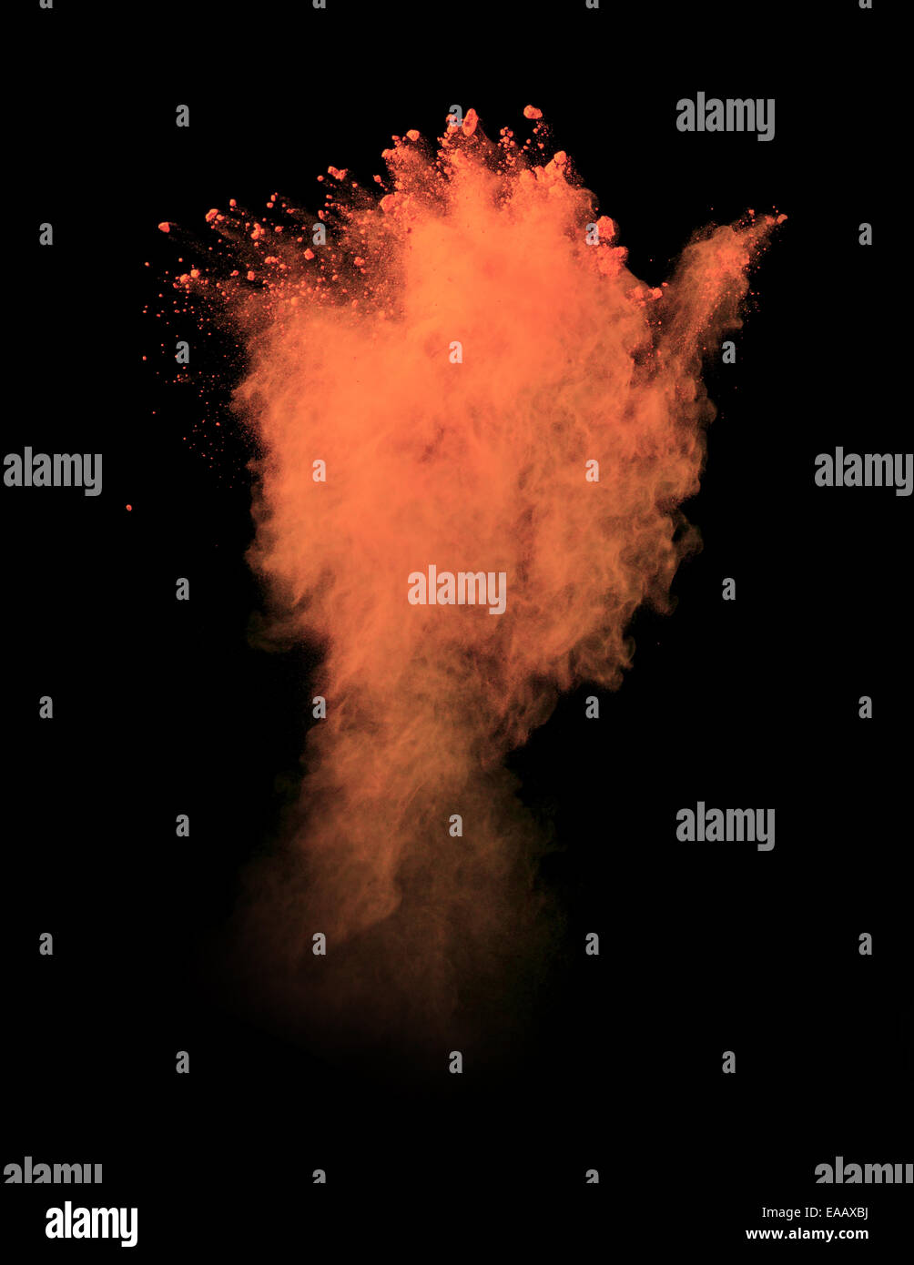 Freeze motion of orange dust explosion isolated on black background ...
