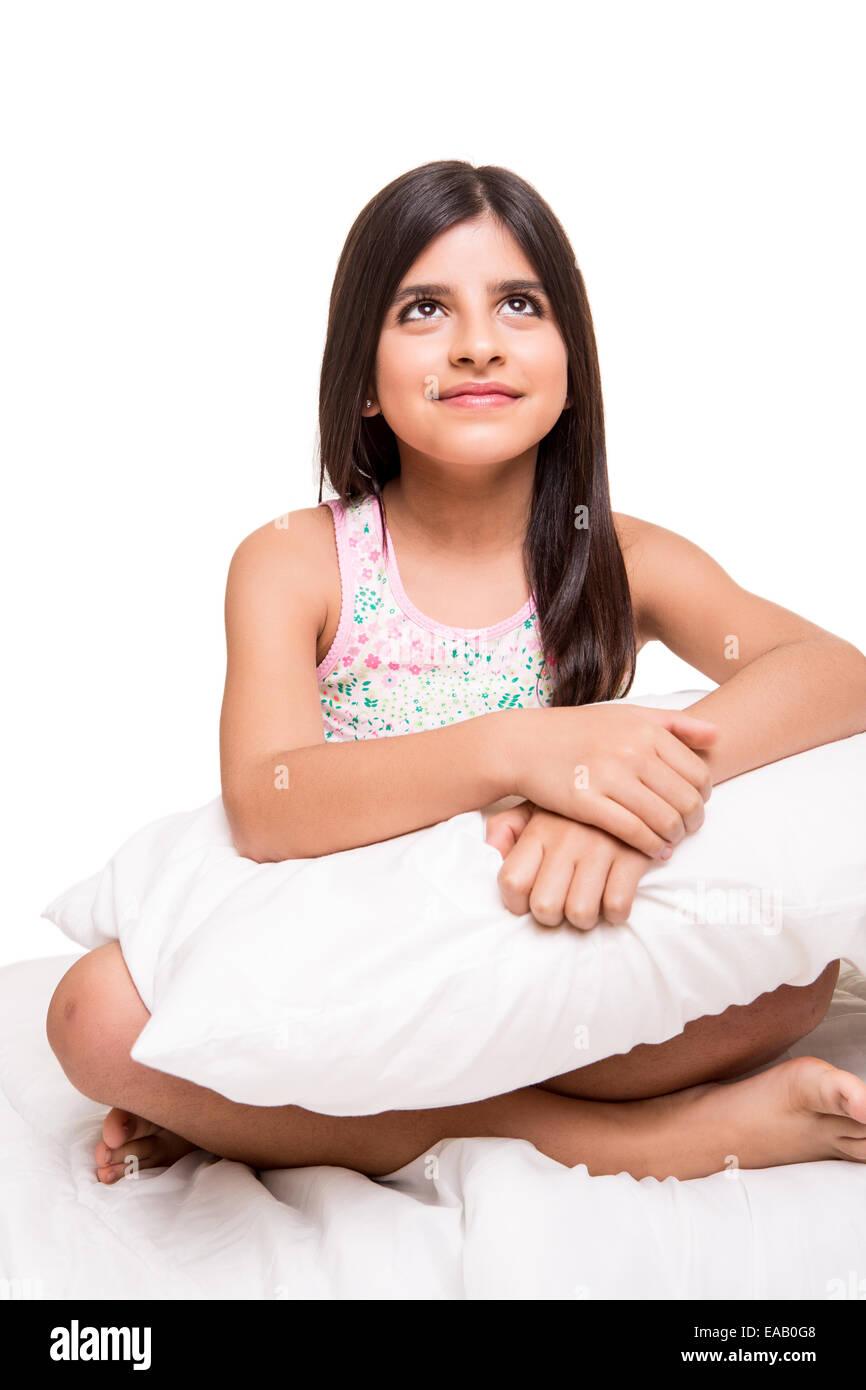 Little cute girl grabbing pillow over white Stock Photo - Alamy