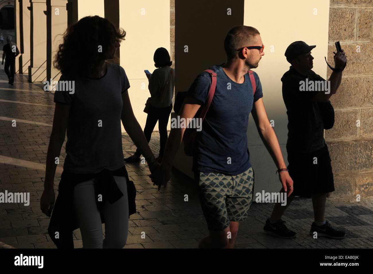 Tourists walk in a Renaissance arcade at Malostranske Square in Prague ...