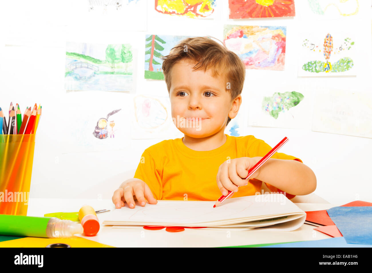 Boy drawing with pencil on the paper at table Stock Photo - Alamy