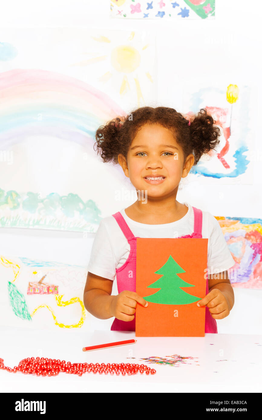 Girl holds carton card with Xmas tree and stands Stock Photo - Alamy