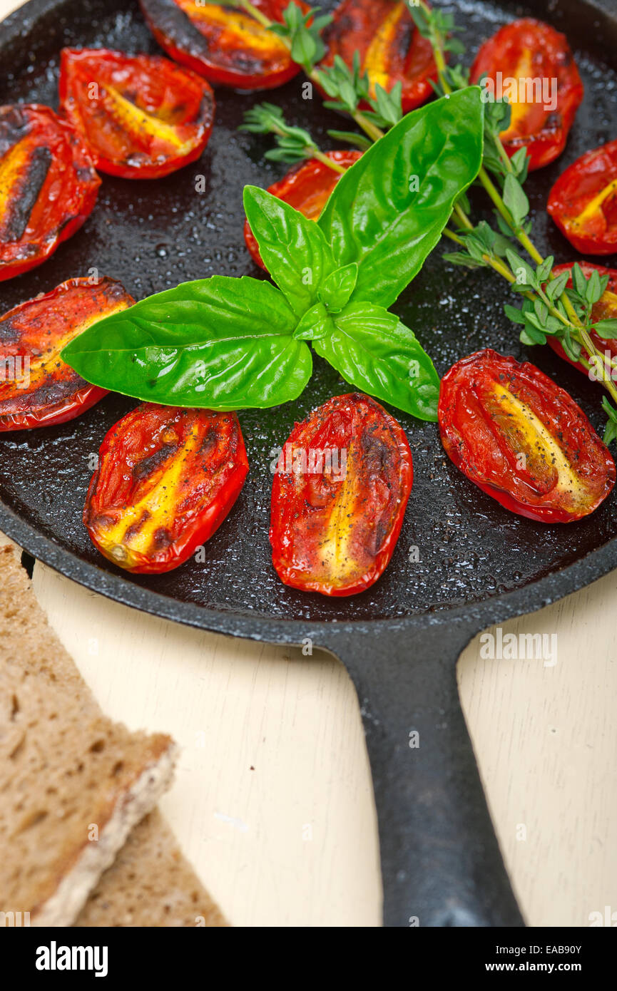 oven baked cherry tomatoes with basil and thyme on a cast iron skillet ...