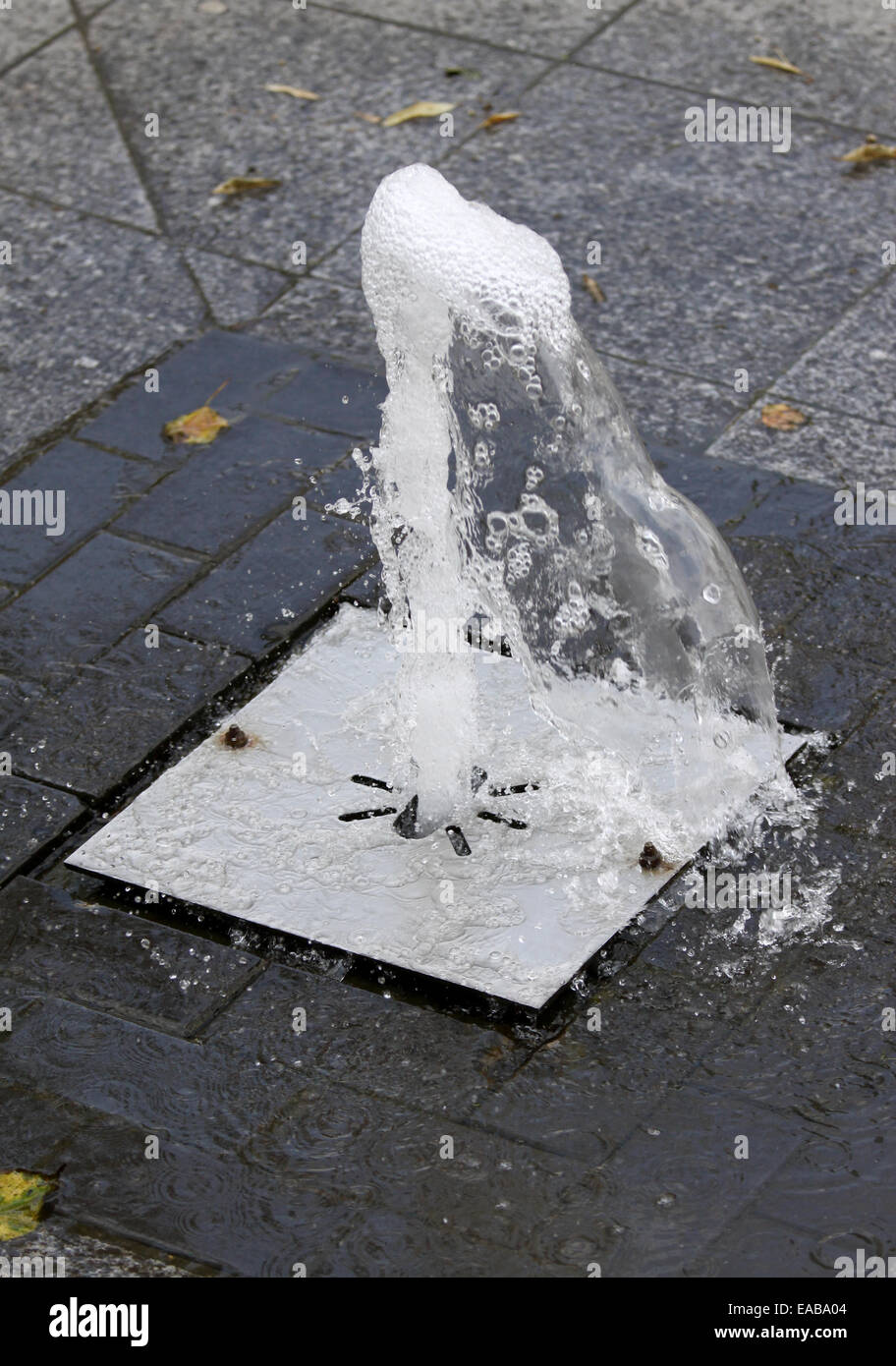 Little fountain on the pavement in city park Stock Photo - Alamy