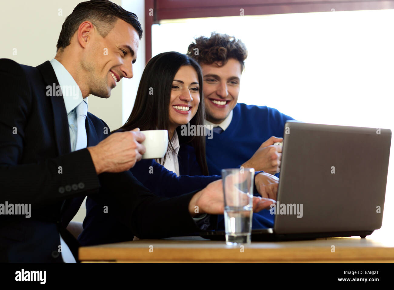 Business people using laptop together in office Stock Photo - Alamy