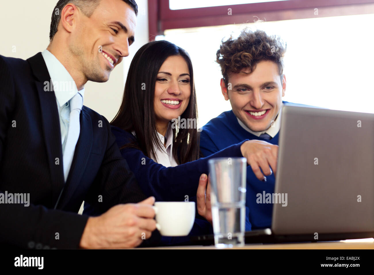Smiling business people working on the laptop Stock Photo - Alamy