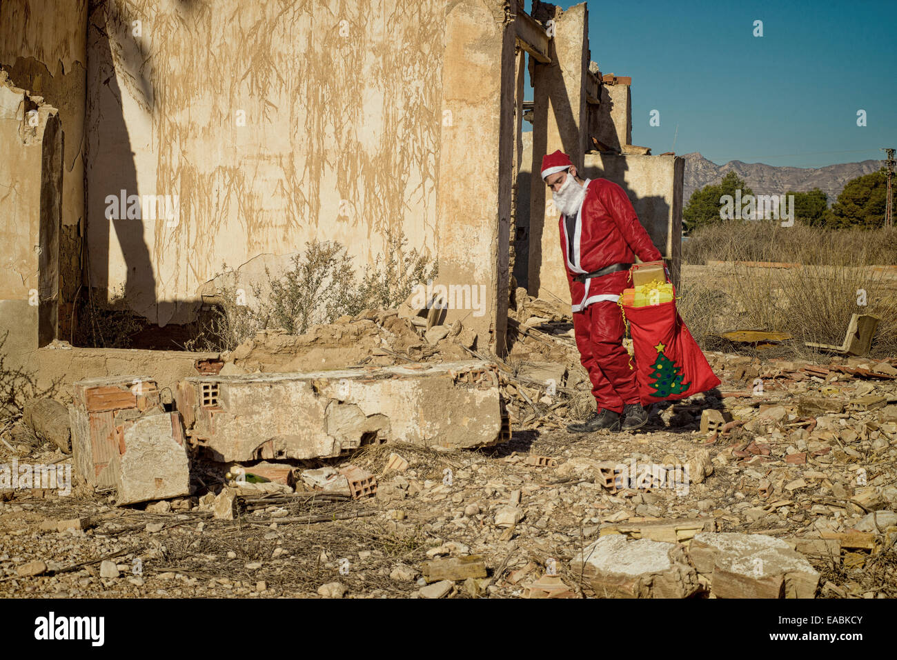 A fed up Santa trudging along with his sack Stock Photo - Alamy