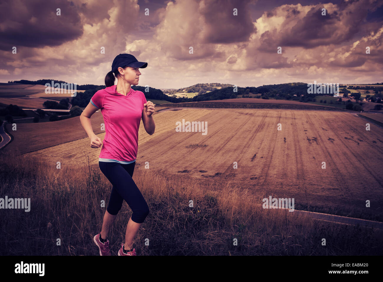a woman running through the rural landscape Stock Photo - Alamy