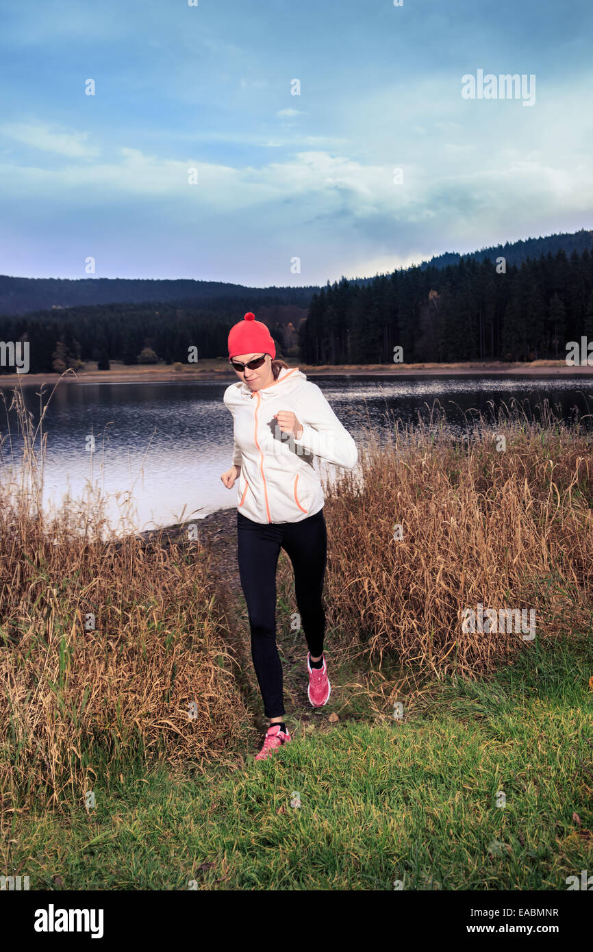 woman running through the forest by the lake Stock Photo - Alamy