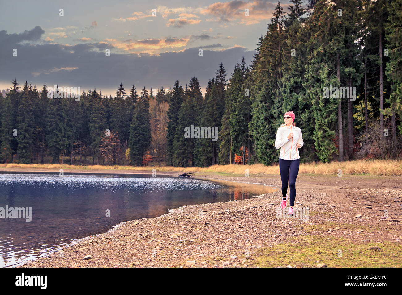 woman running through the forest by the lake Stock Photo - Alamy