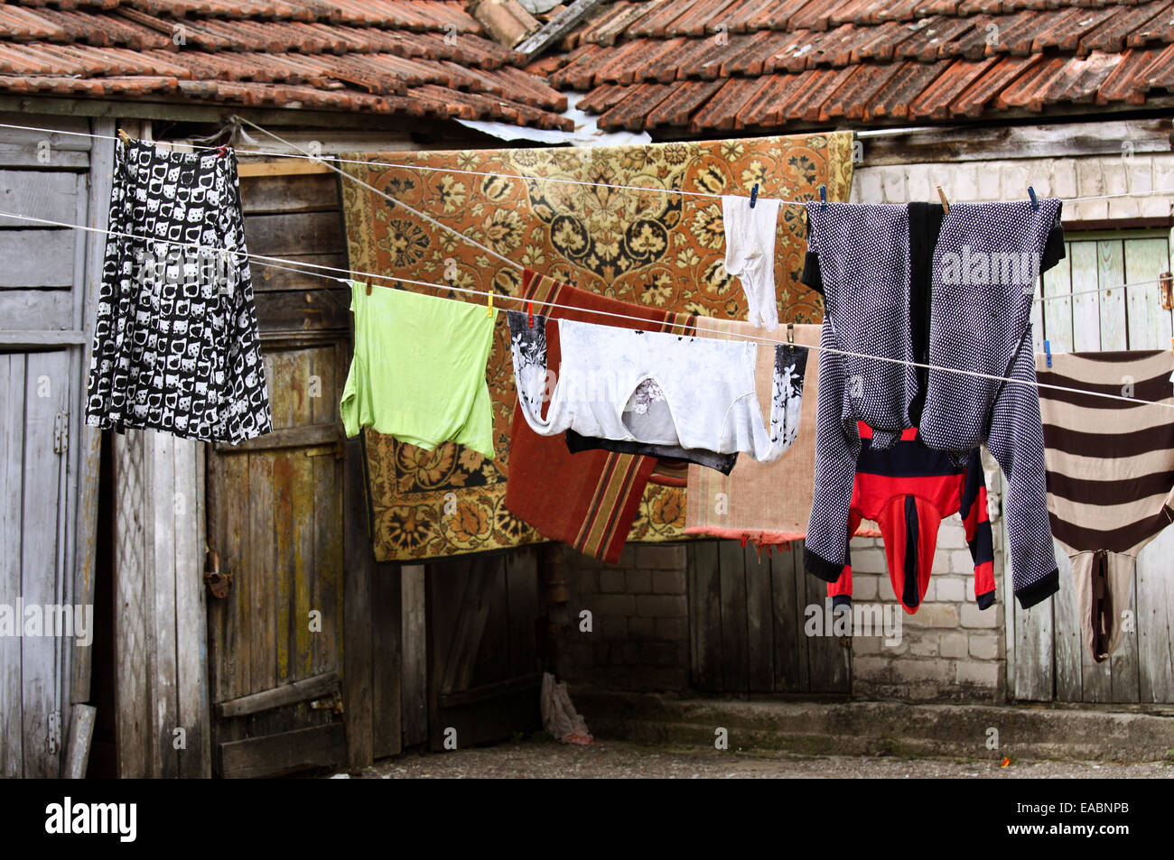 Laundry hanging outdoors in poor rural environment Stock Photo - Alamy