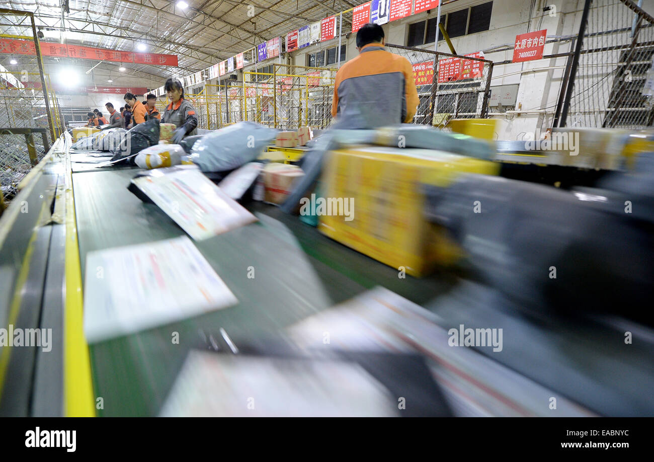 Yinchuan. 11th Nov, 2014. Workers sort out packages in a dispatching ...