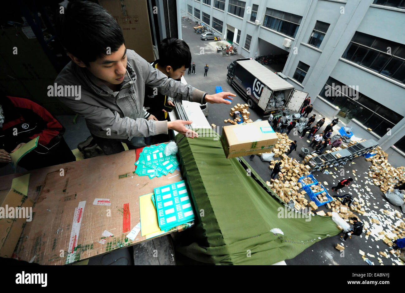 Hefei. 11th Nov, 2014. Workers transfer outgoing packages at an ...