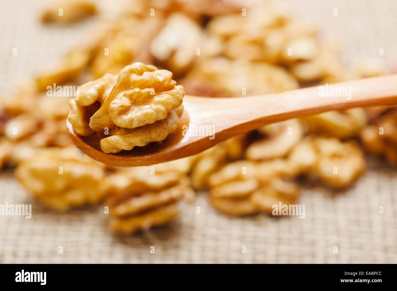 Whole nutmeat in background and on wooden spoon Stock Photo - Alamy