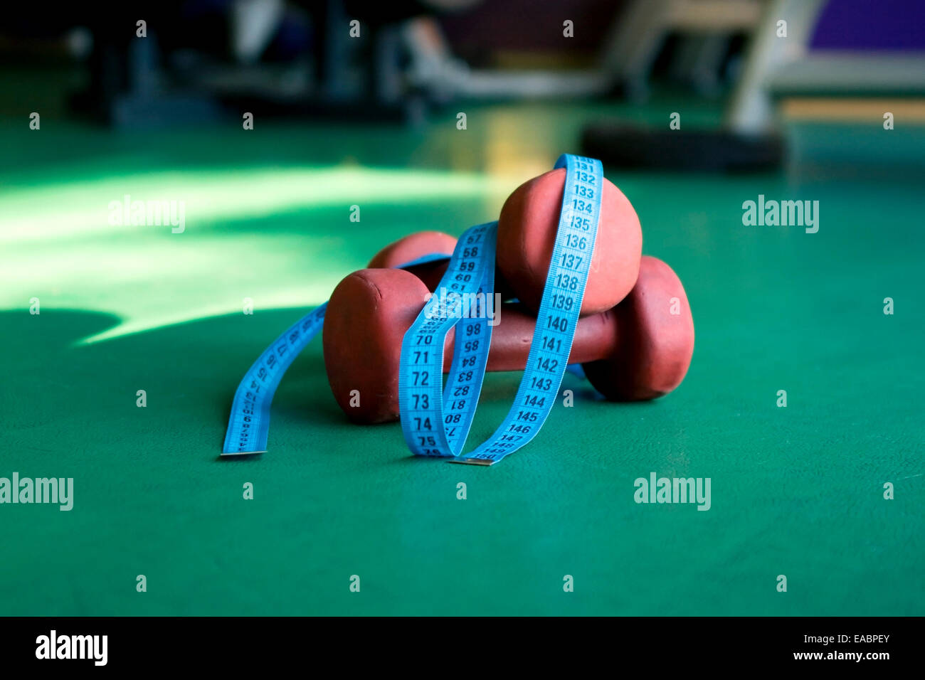 Set of dumbbells and tape measuring in gym Stock Photo - Alamy