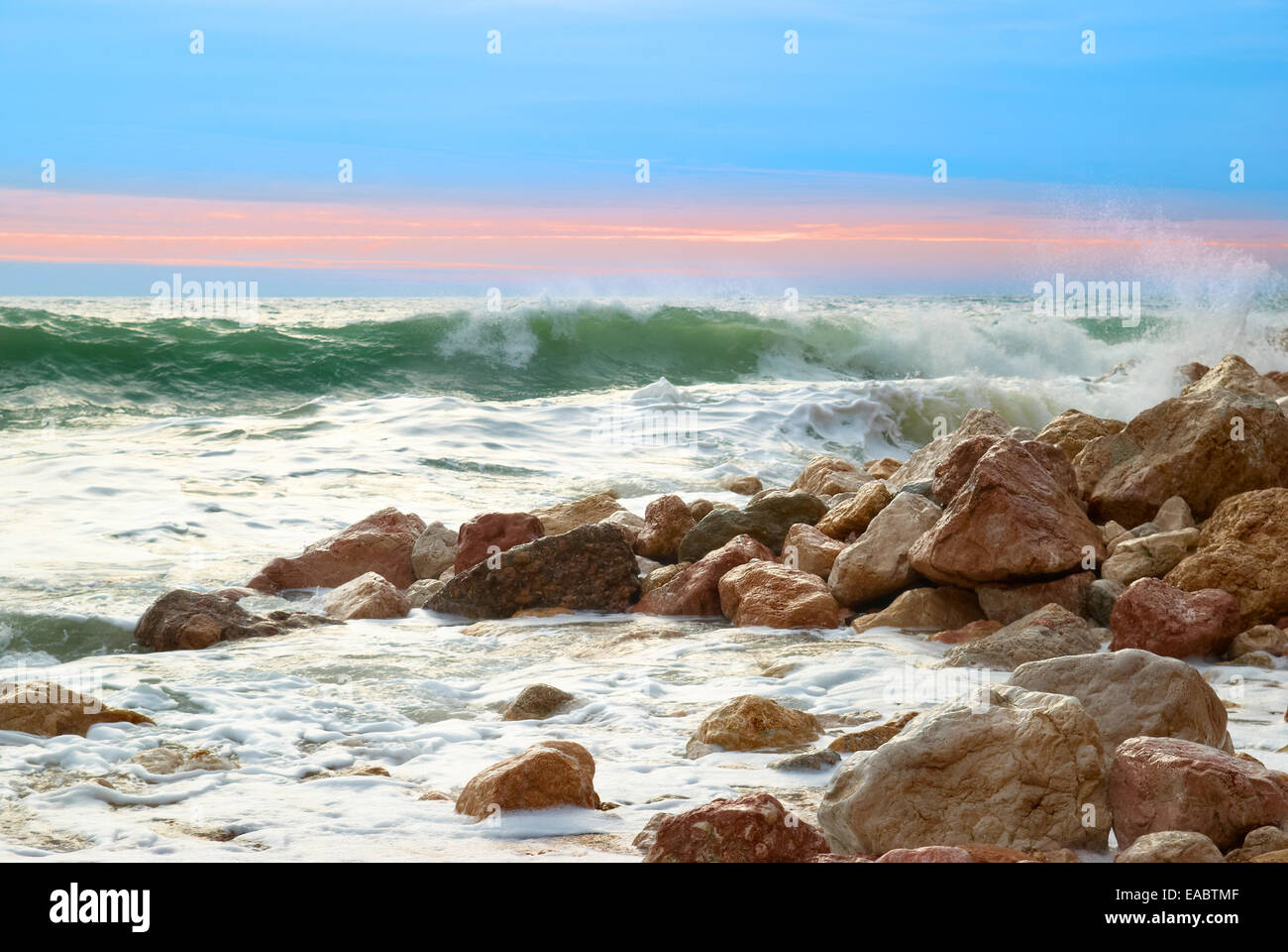 Sea landscape with waves on the beach against sunset Stock Photo - Alamy
