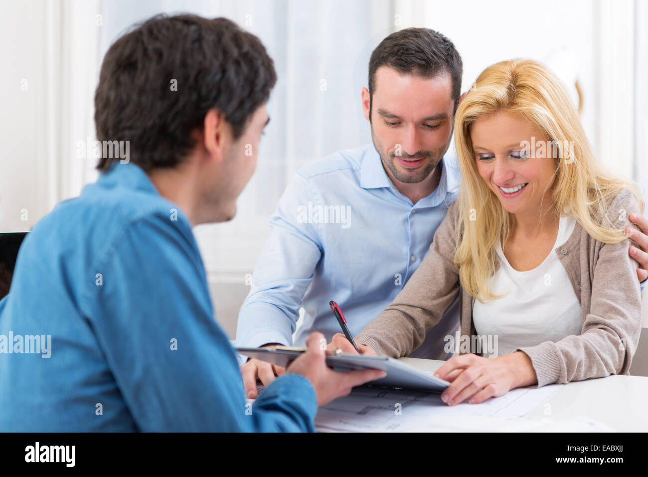 View of a Young attractive couple signing contract Stock Photo - Alamy