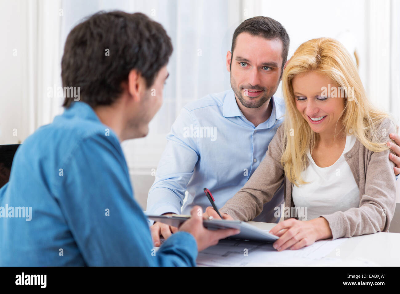 View of a Young attractive couple signing contract Stock Photo - Alamy