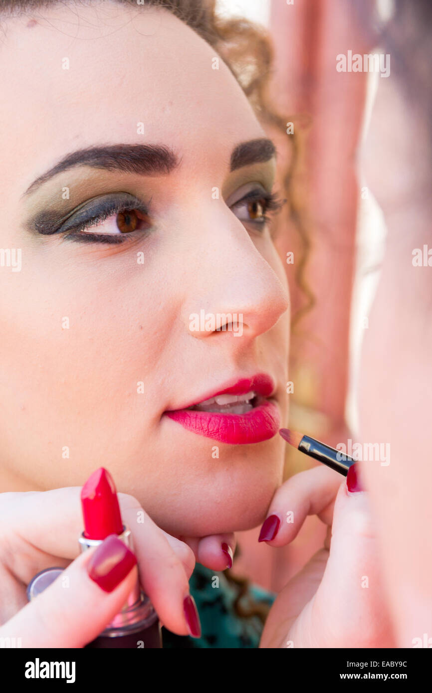 Stylist and makeup artist making up beautiful face on woman model ...