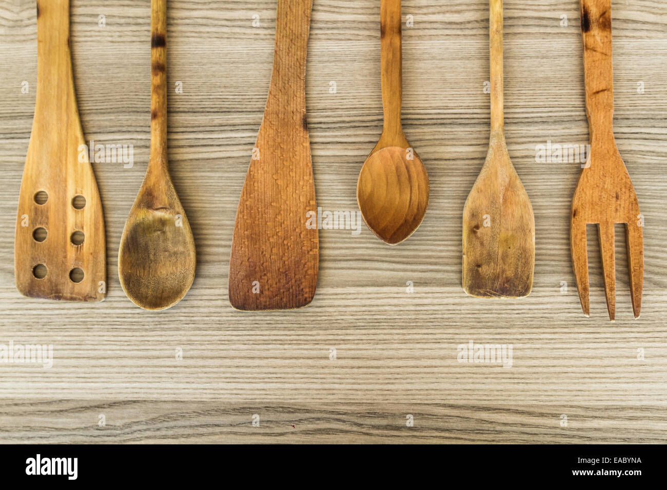 Kitchen wooden utensil of scapula, spoon and fork on wooden table Stock ...