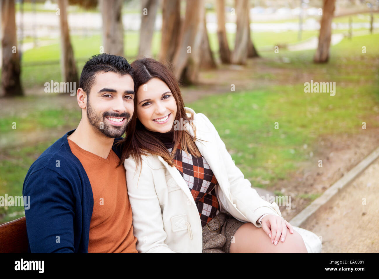 Young romantic couple on a bench in park Stock Photo - Alamy