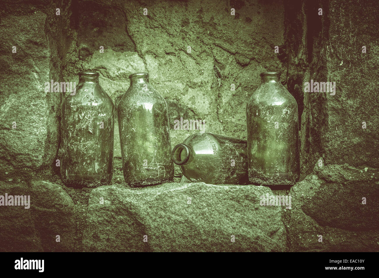 Old beer bottles on a stone wall Stock Photo - Alamy