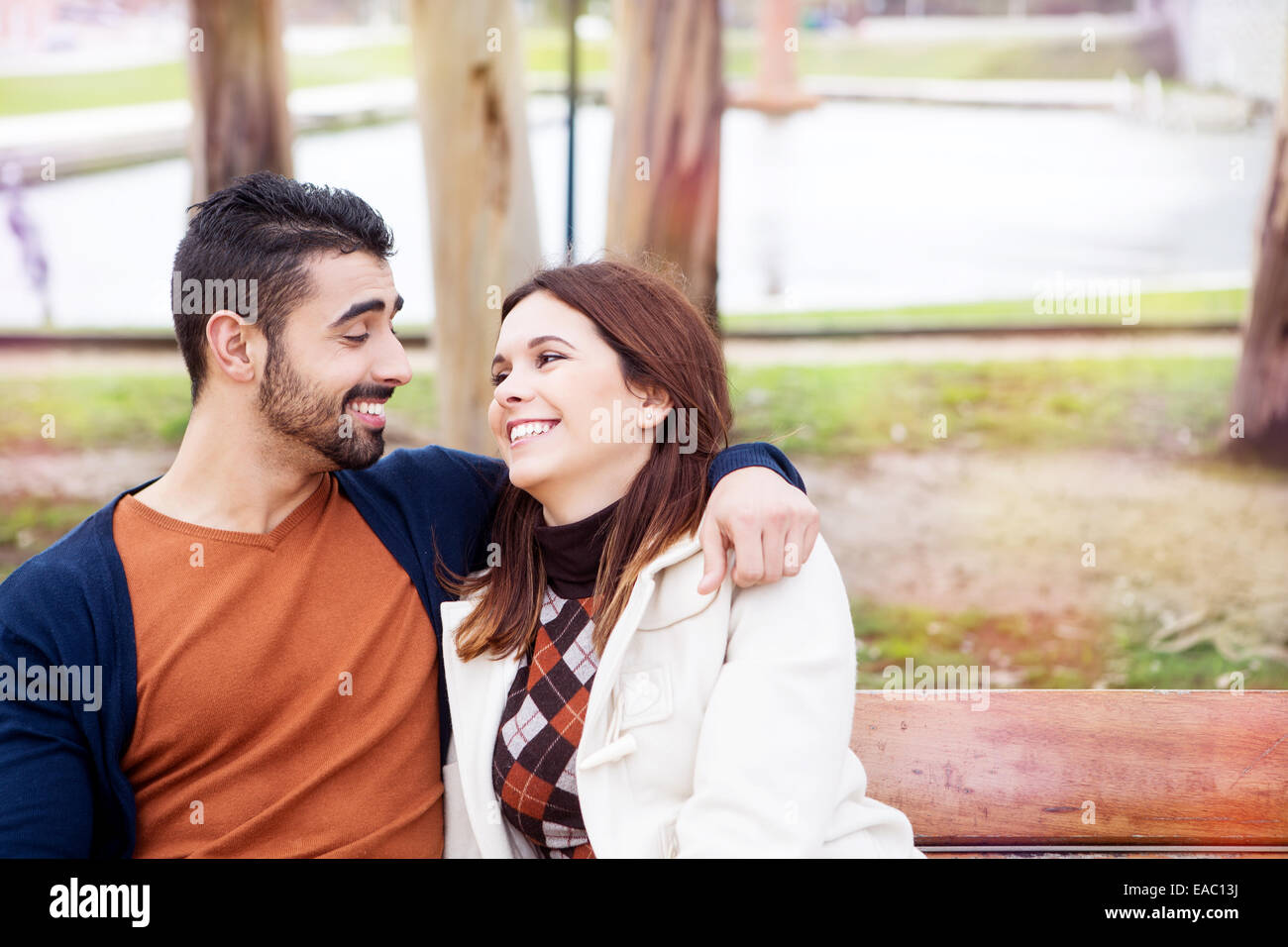 Young romantic couple on a bench in park Stock Photo - Alamy
