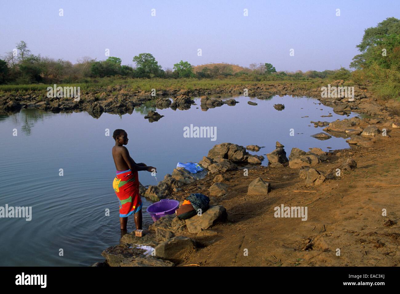 Woman washing clothes in Gambia river, Niokolo Koba national park ...