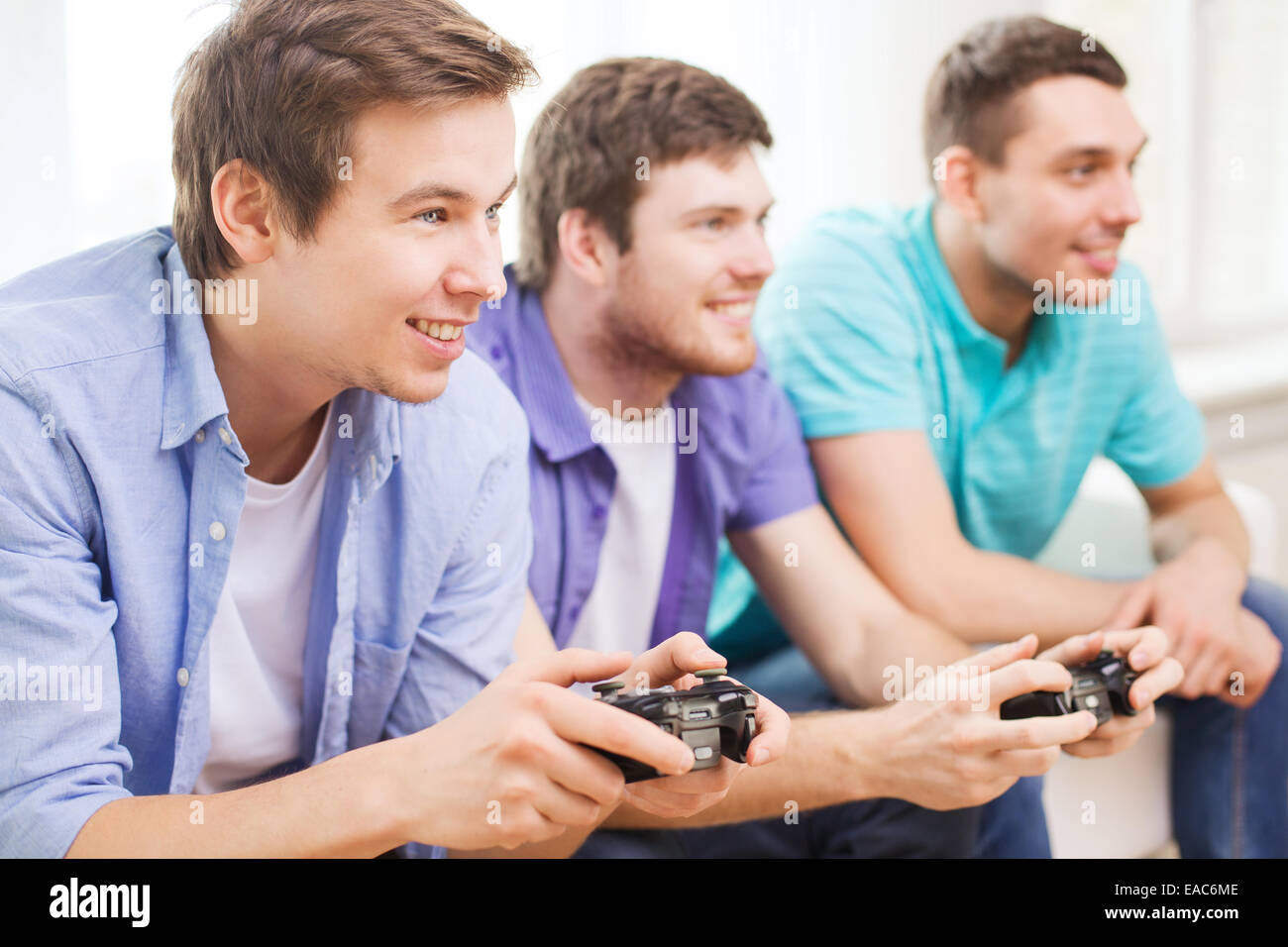 Video game playing friends sofa hi-res stock photography and images - Alamy