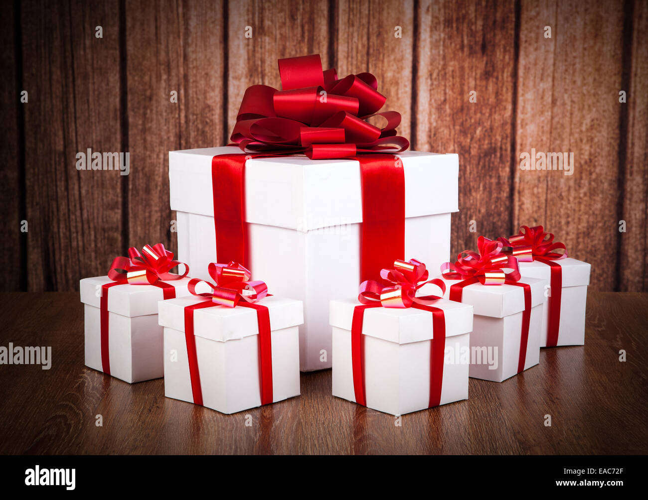 one large white gift box and white gift boxes on a wood background ...