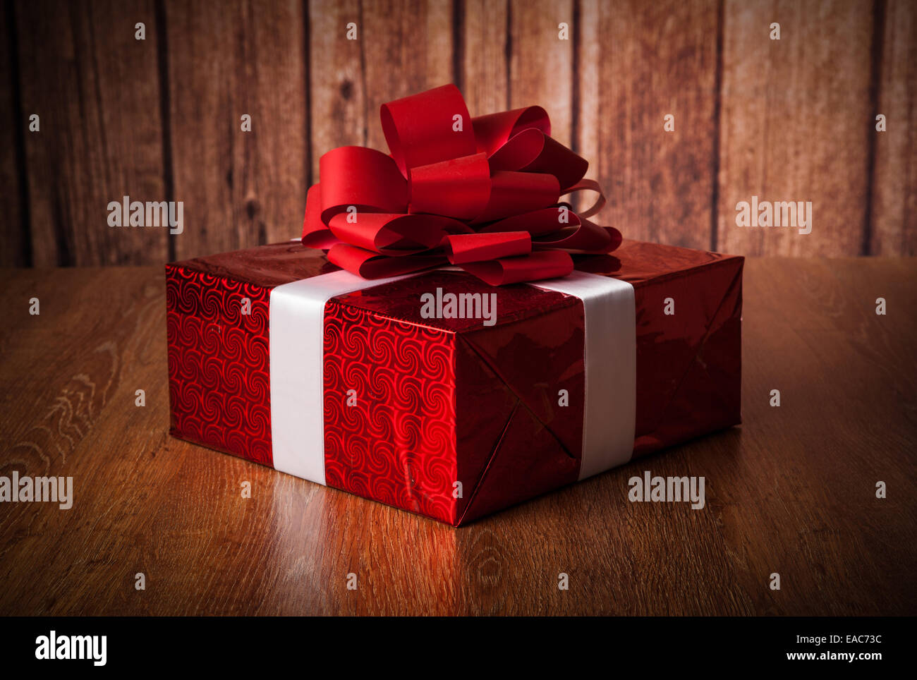 one large red gift box on a wood background Stock Photo - Alamy