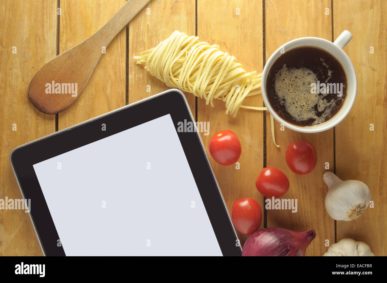 Computer tablet with space surrounded by fresh cooking ingredients ...