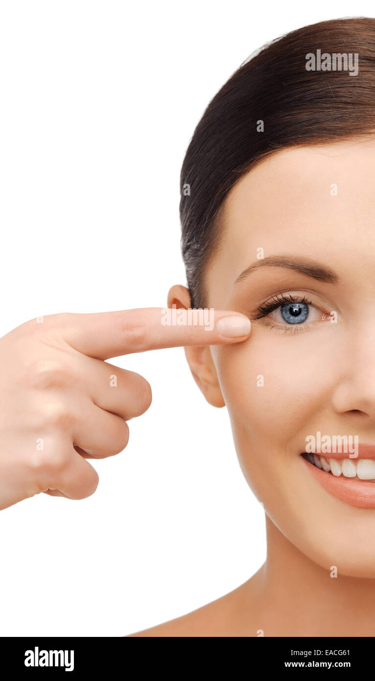 young smiling woman pointing to her eye Stock Photo - Alamy