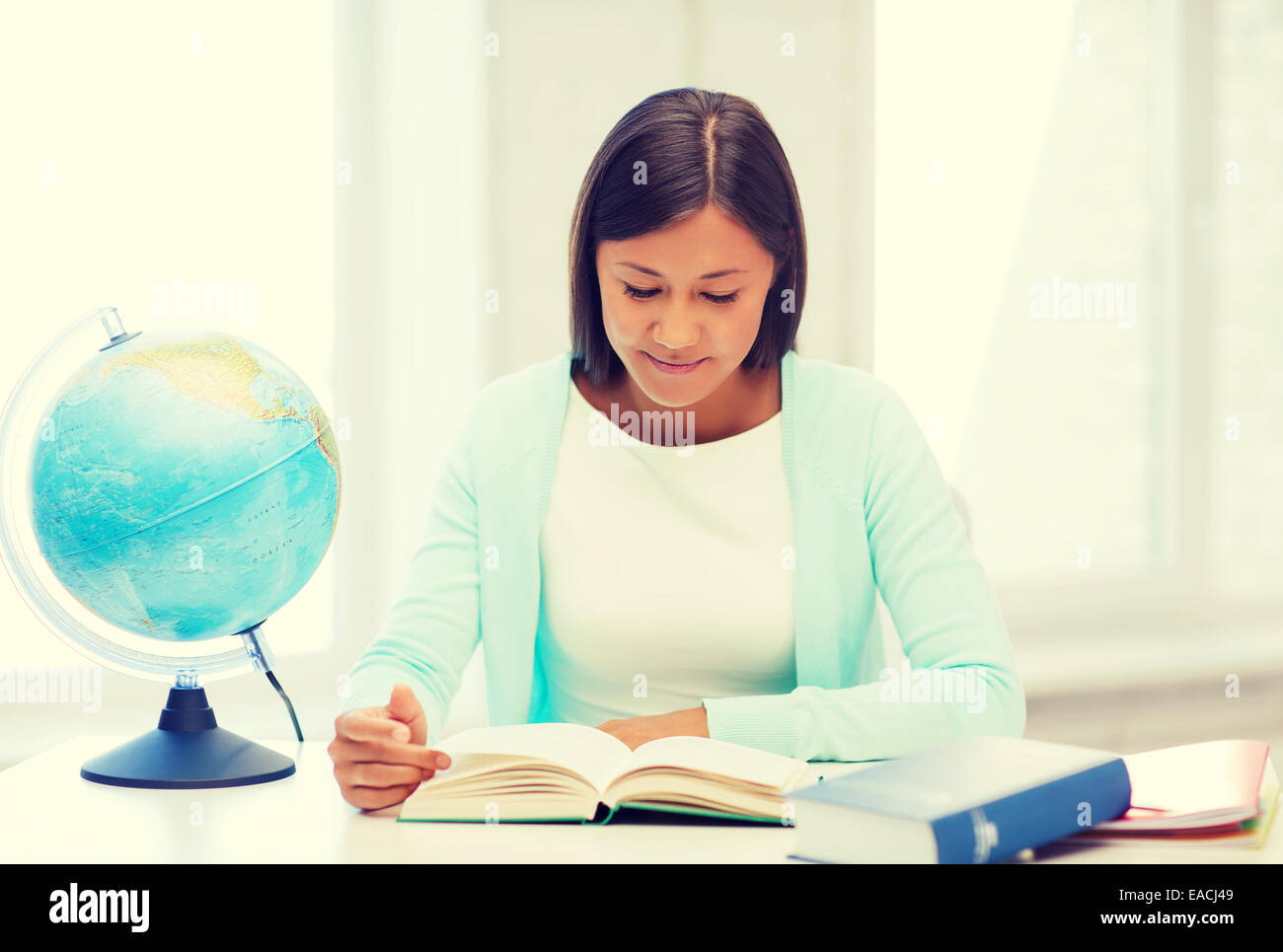 teacher with globe and book at school Stock Photo - Alamy